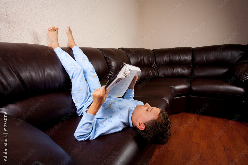 Cute kid sitting upside down reading a big book Stock Photo | Adobe Stock