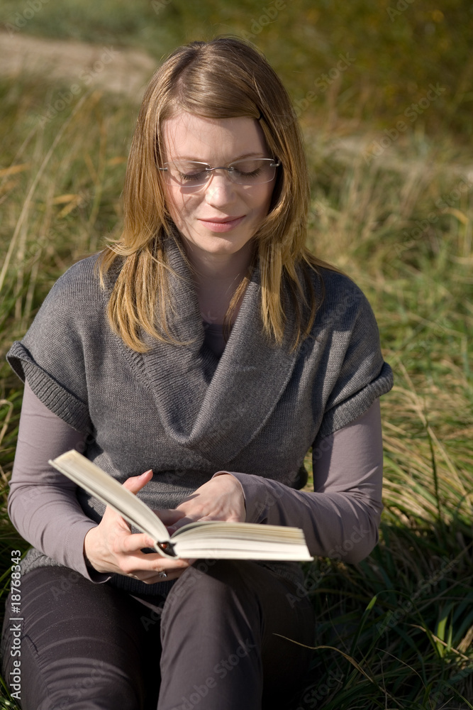 Foto de Frau liest Buch am Strand do Stock | Adobe Stock
