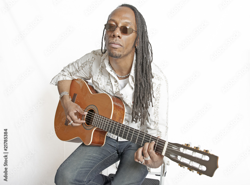African American guitarist is seated playing an acoustic guitar Stock ...