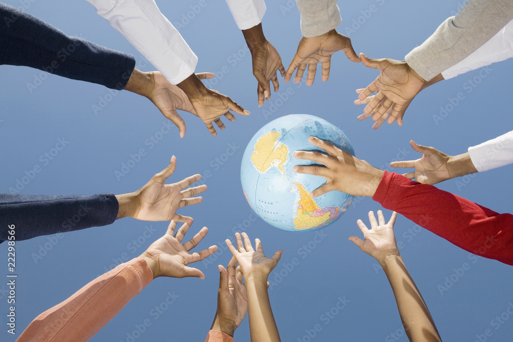 Multi-ethnic hands reaching for globe ball Stock Photo | Adobe Stock