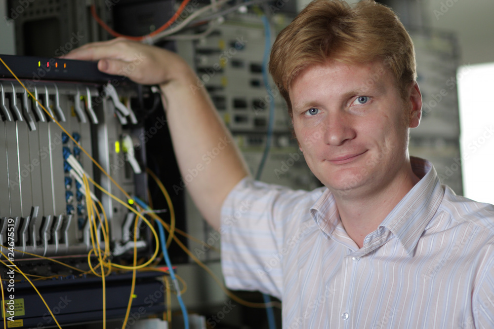 Telecom engineer poses on multiplexer background Stock Photo | Adobe Stock