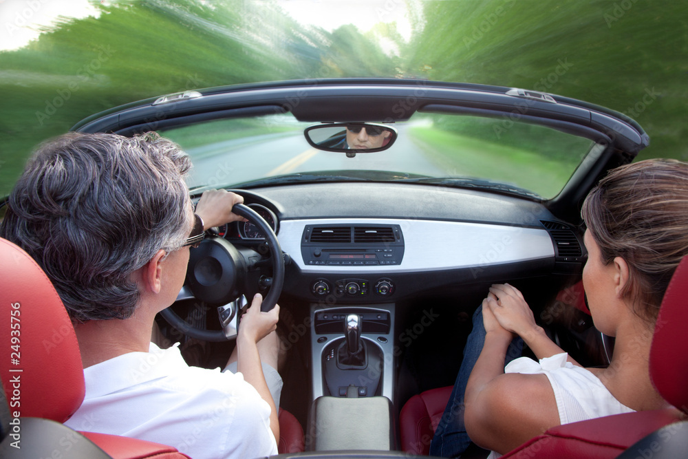 Man and woman driving convertible Stock Photo | Adobe Stock