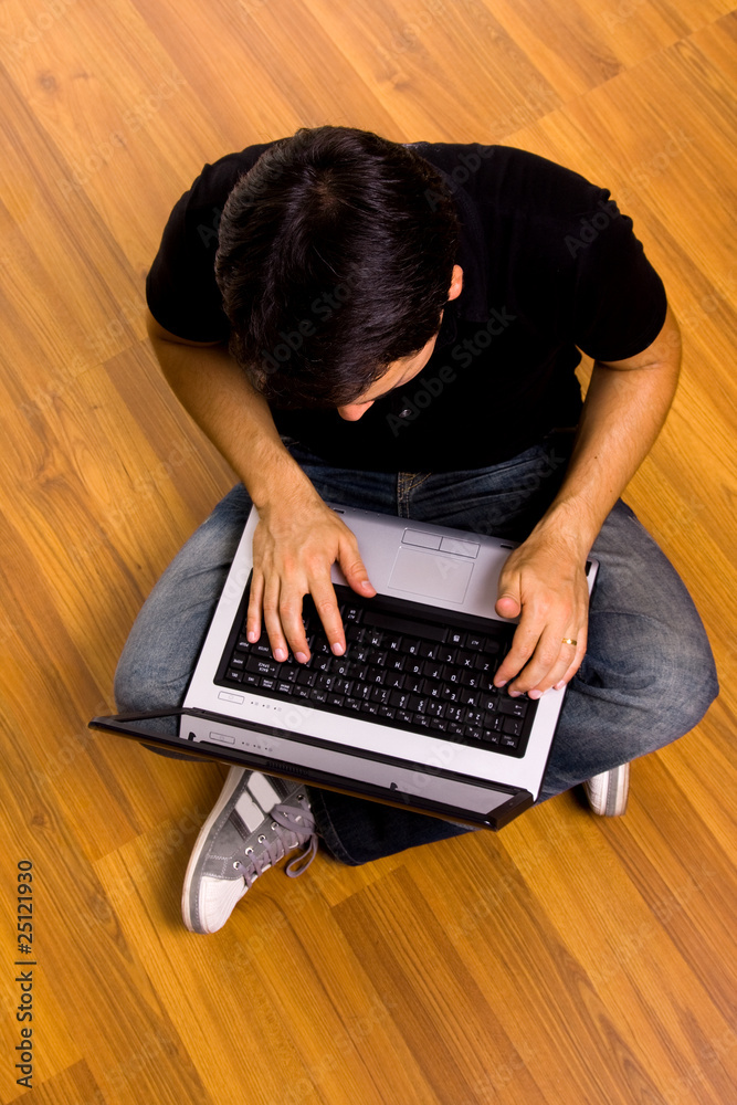 young man sitting on the floor working on laptop computer at hom Stock ...