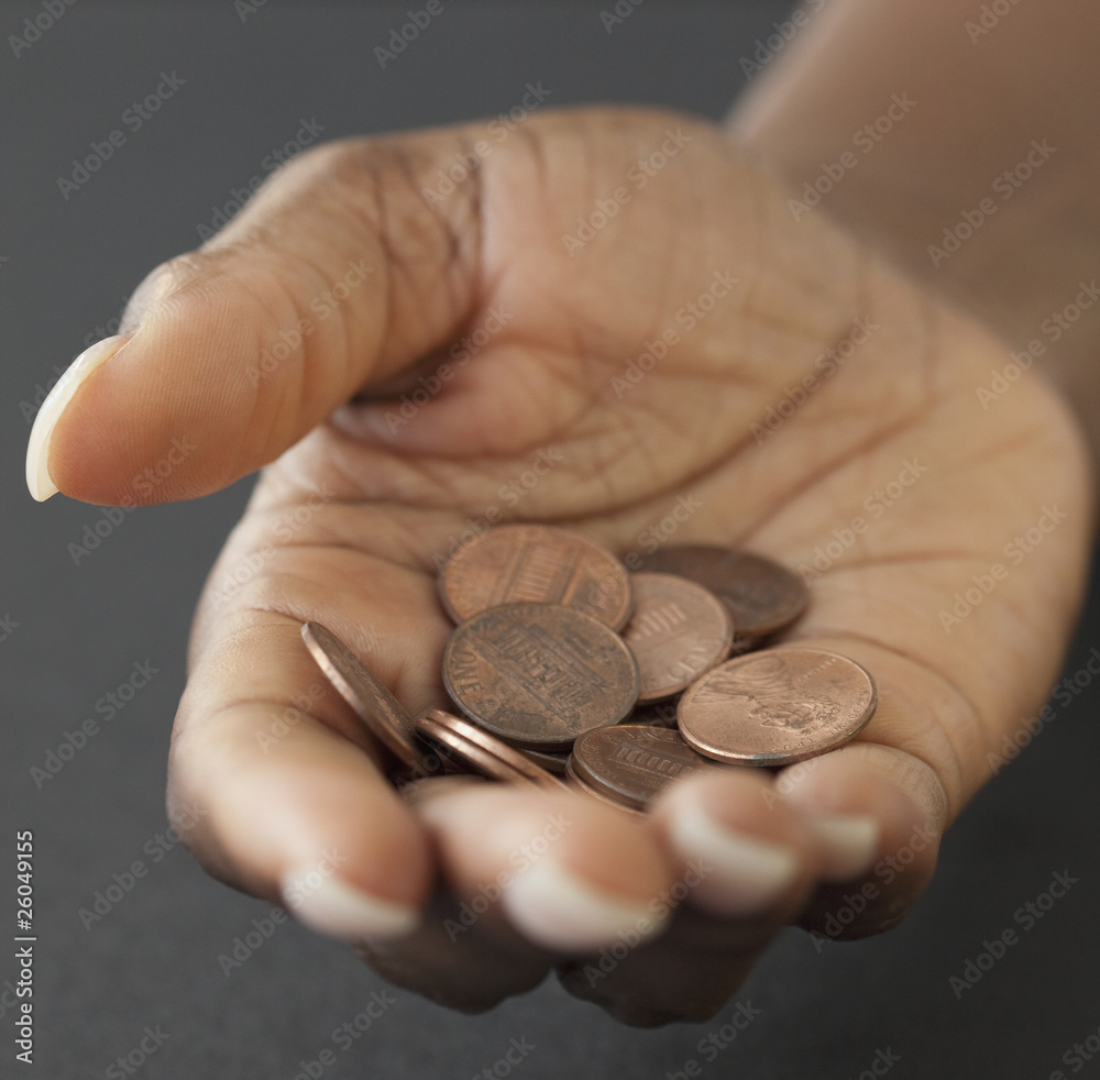 African woman holding handful of pennies Stock Photo | Adobe Stock