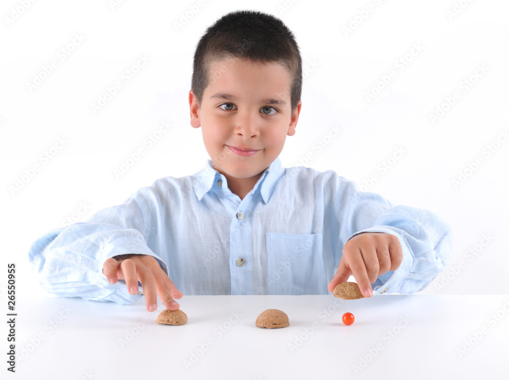 Cute boy playing traditional shell game with walnut shells. Stock Photo ...