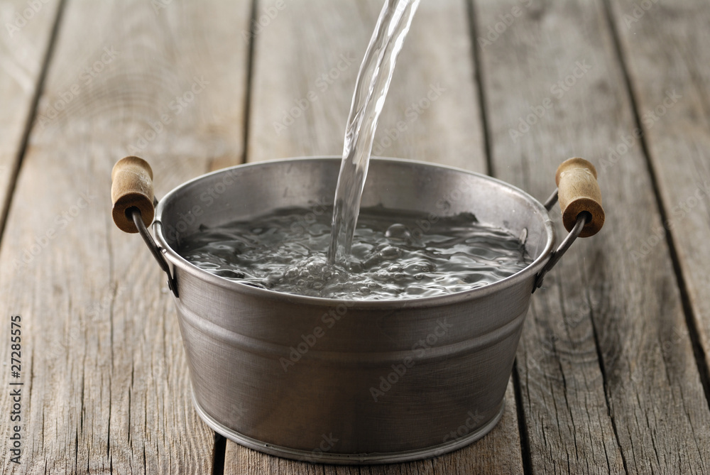 Eau versée dans une bassine Photos | Adobe Stock