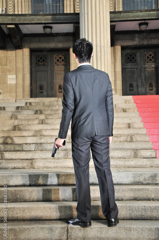 Asian Man with a Gun with back facing viewer Stock Photo | Adobe Stock