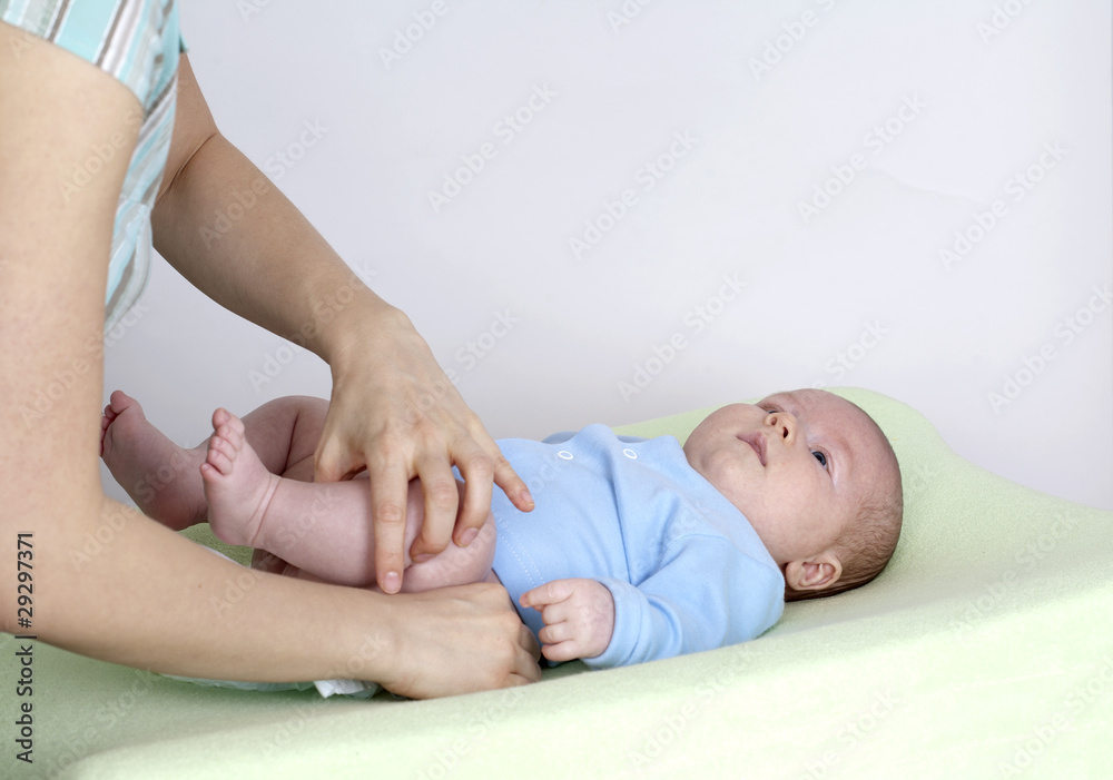 Caring young mother changing the diaper of her baby at home Stock Photo ...
