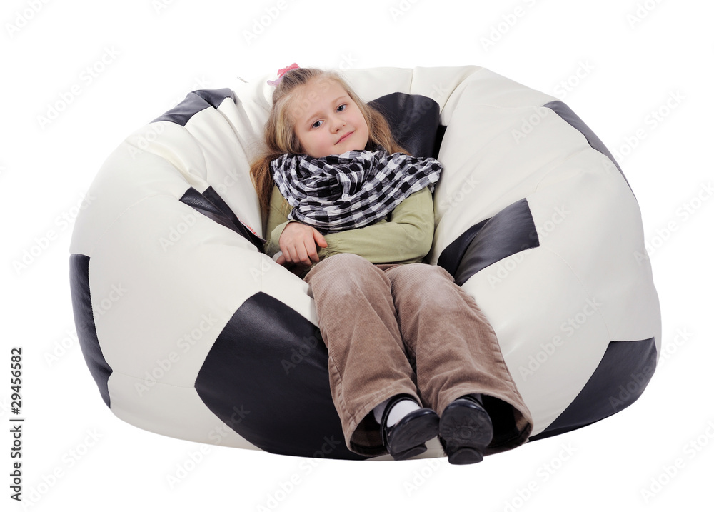 Girl sitting on an inflatable chair in the form of a soccer ball Stock ...