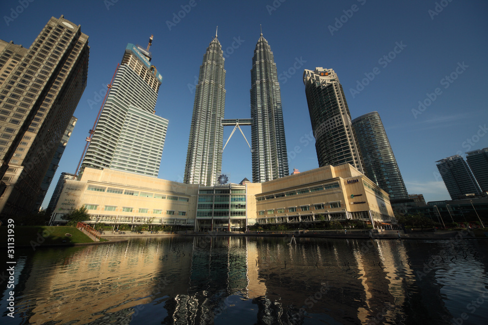 Petronas Twin Towers - tallest twin buildings in the world at the sunrise light with reflection ...