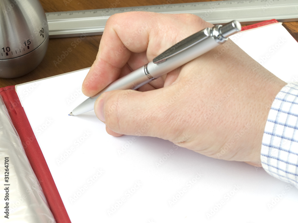 Hand holding a pen and sheet of a paper laying on a desk Stock Photo ...