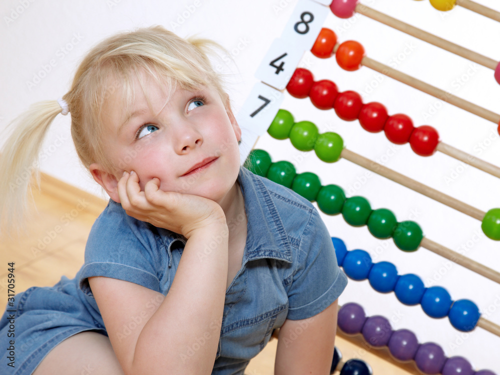 Little blond child using an abacus to learn Stock Photo | Adobe Stock