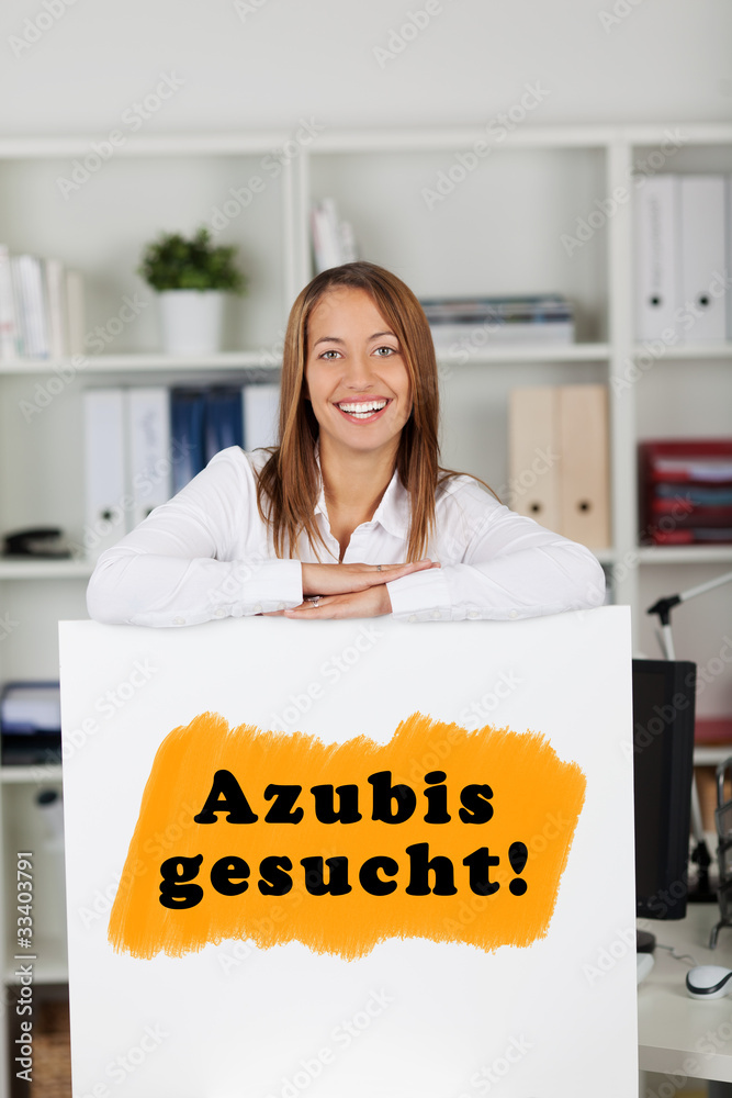 lächelnde frau im büro zeigt schild azubis gesucht ภาพถ่ายสต็อก | Adobe ...