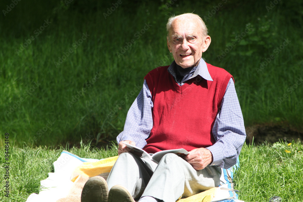 Foto de Rüstiger Rentner lachend beim Lesen in grüner Natur do Stock ...