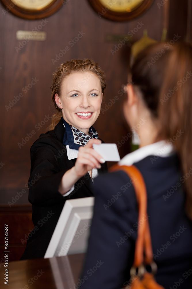 rezeptionistin überreicht einem gast die karte Stock-Foto | Adobe Stock