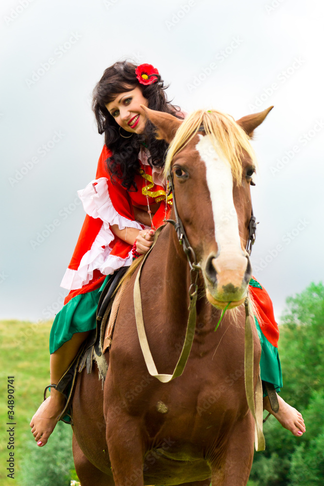 Beautiful gypsy girl riding a horse Stock Photo | Adobe Stock