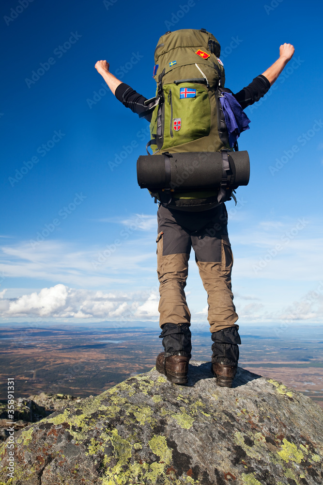 Bergsteiger mit Rucksack auf dem Gipfel Stock-Foto | Adobe Stock