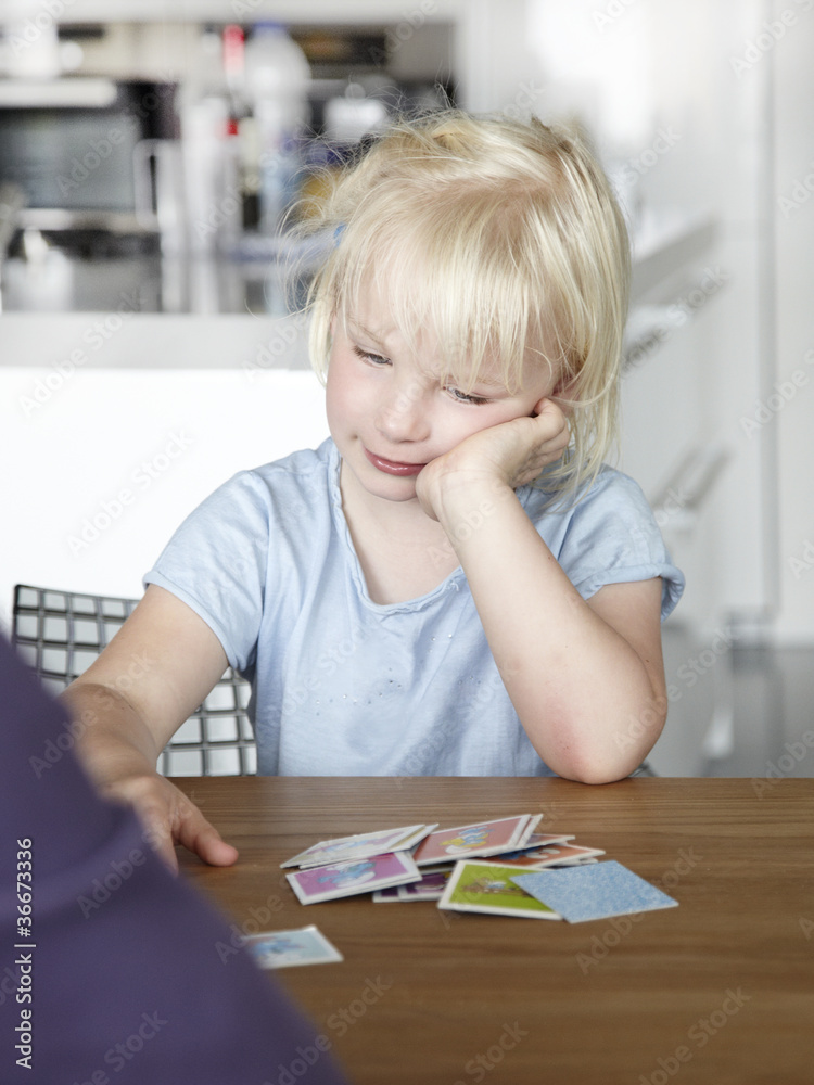 Cute little girl playing concentrated memory at the table Stock Photo ...