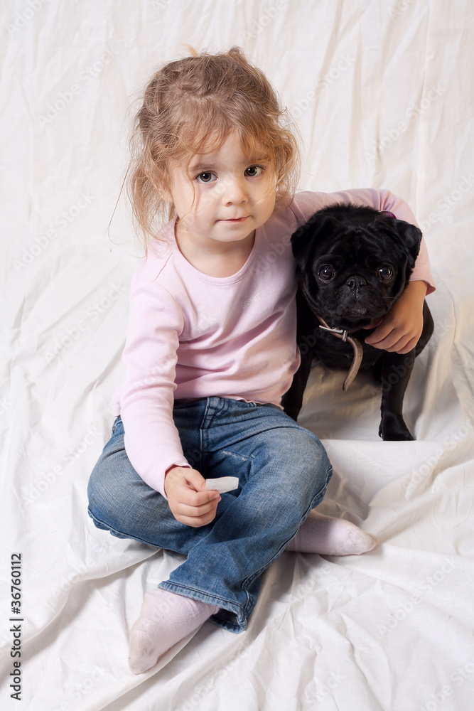 Kleines Mädchen mit Mops im Arm Stock-Foto | Adobe Stock