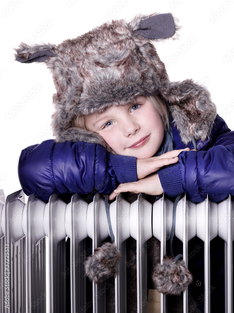 Girl with pelt cap over a radiator looking forward to summertime Stock ...