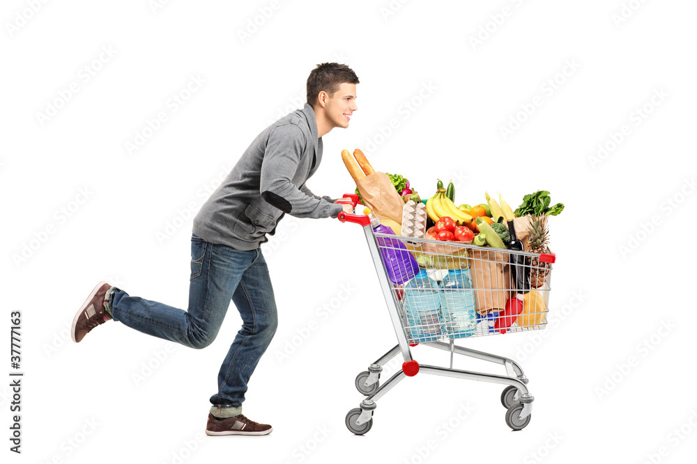 Young man running and pushing a shopping cart full with food Stock ...
