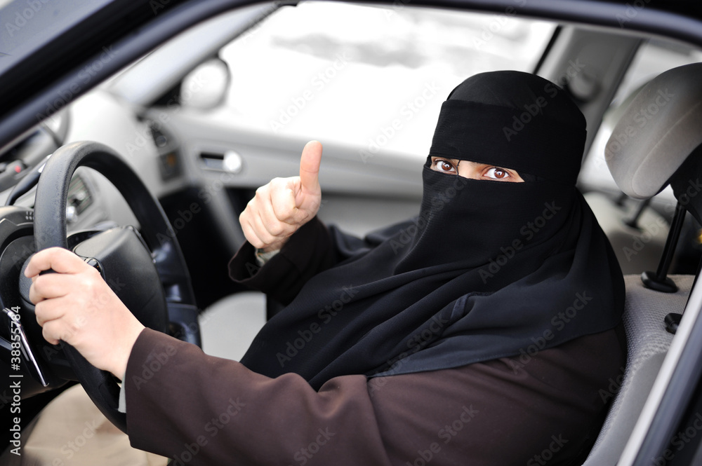 Arabic Muslim woman driving a car and happy for that Stock Photo ...