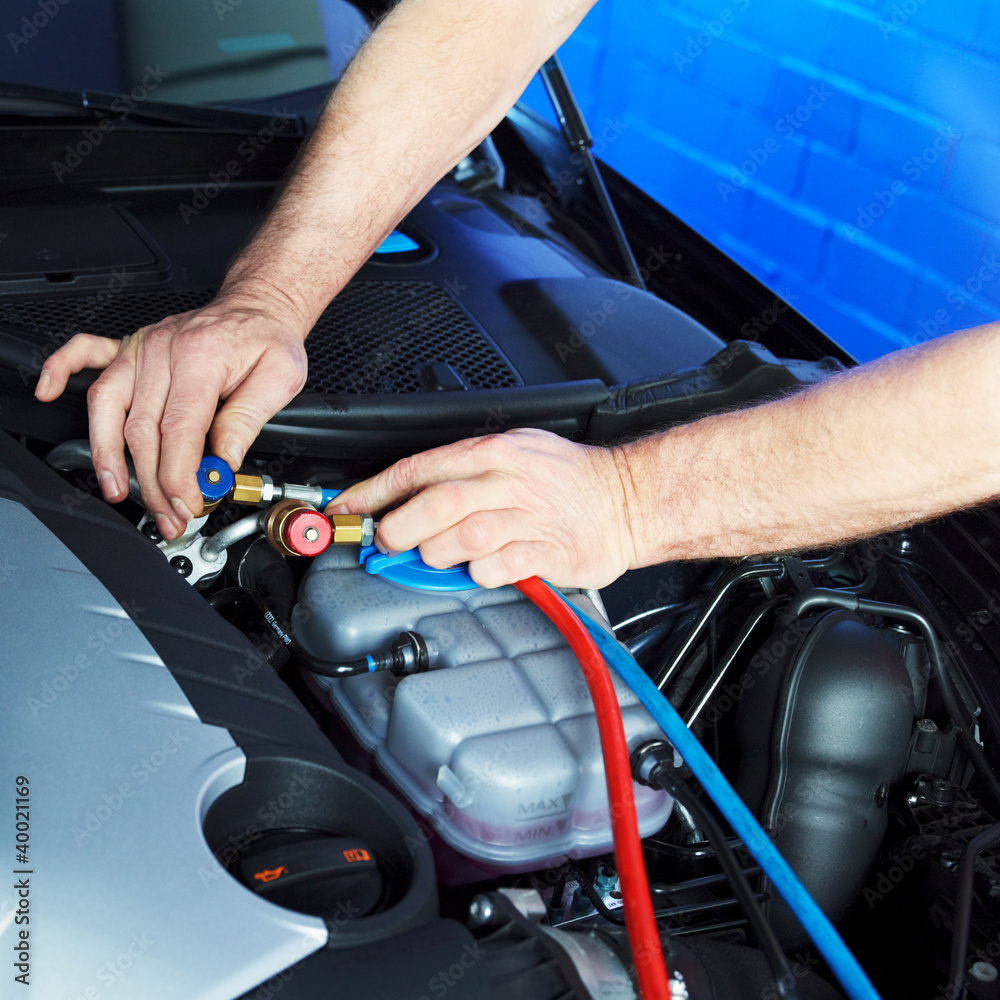 Foto de Motor mechanic works on engine bay with air handling unit do ...