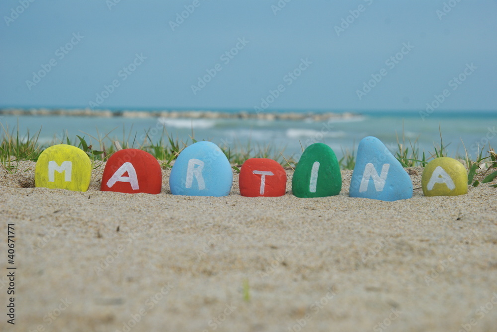 Martina, female name on colourful pebbles on the sand Stock Photo ...
