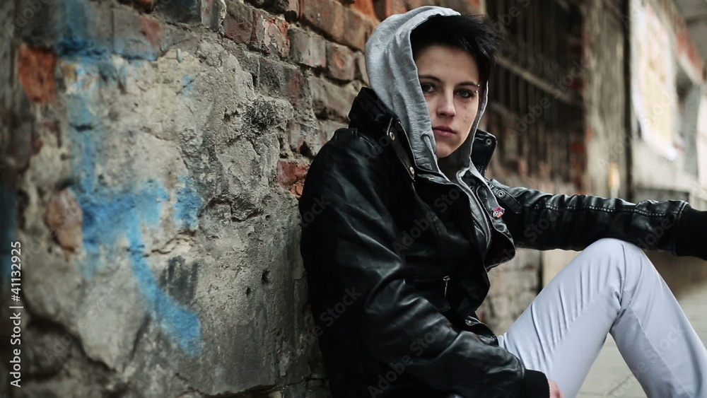 Portrait of young punk girl sitting by the wall, steadicam shot Stock ...