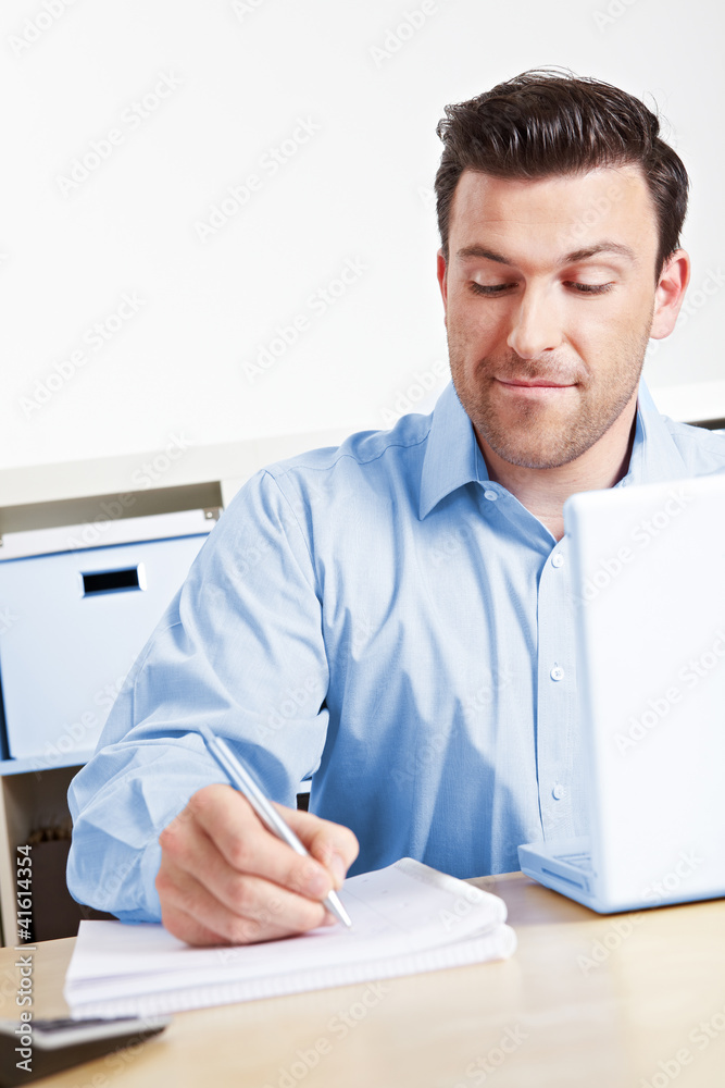 Mann im am Schreibtisch macht Notizen Stock Photo | Adobe Stock