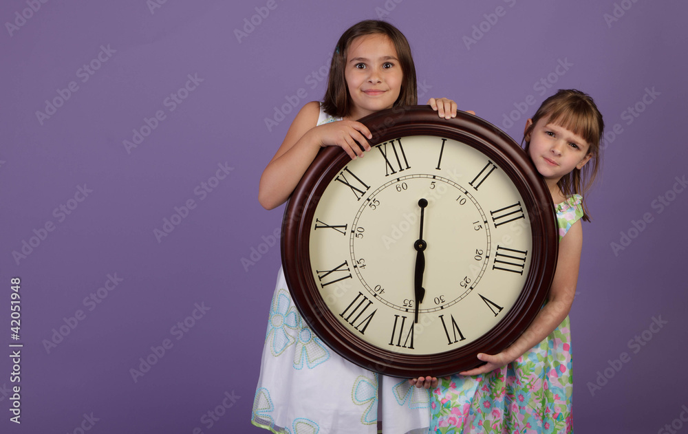 Two girls holding a large wall clock Stock Photo | Adobe Stock