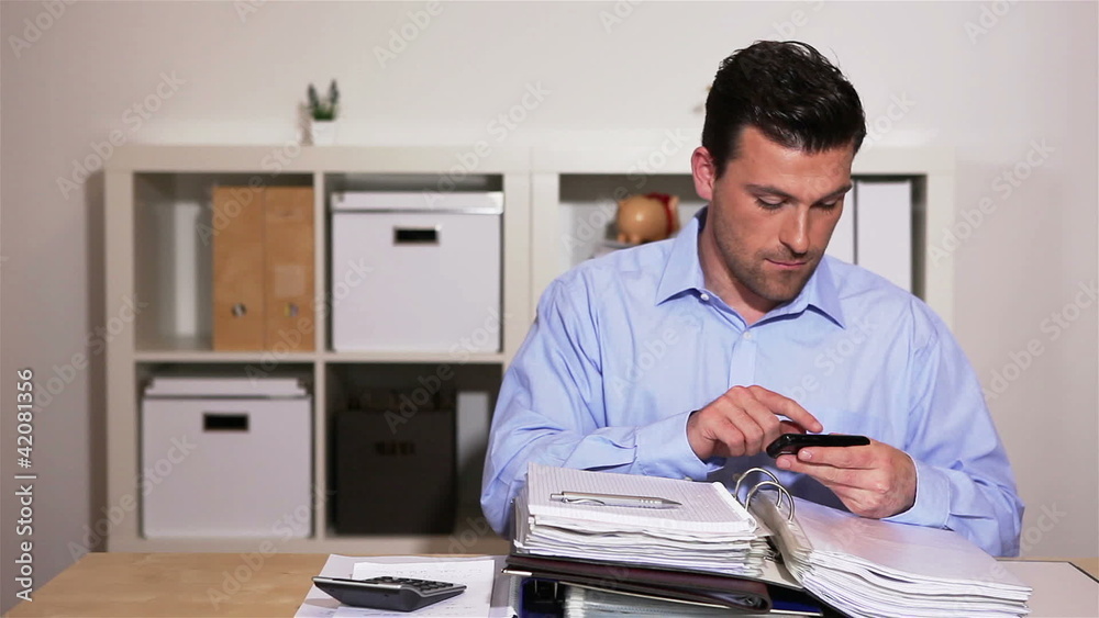 Business man at his desk browing the internet with smartphone Stock ...