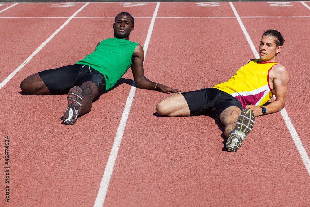 Two Track and Field Athletes Stretching Stock Photo | Adobe Stock