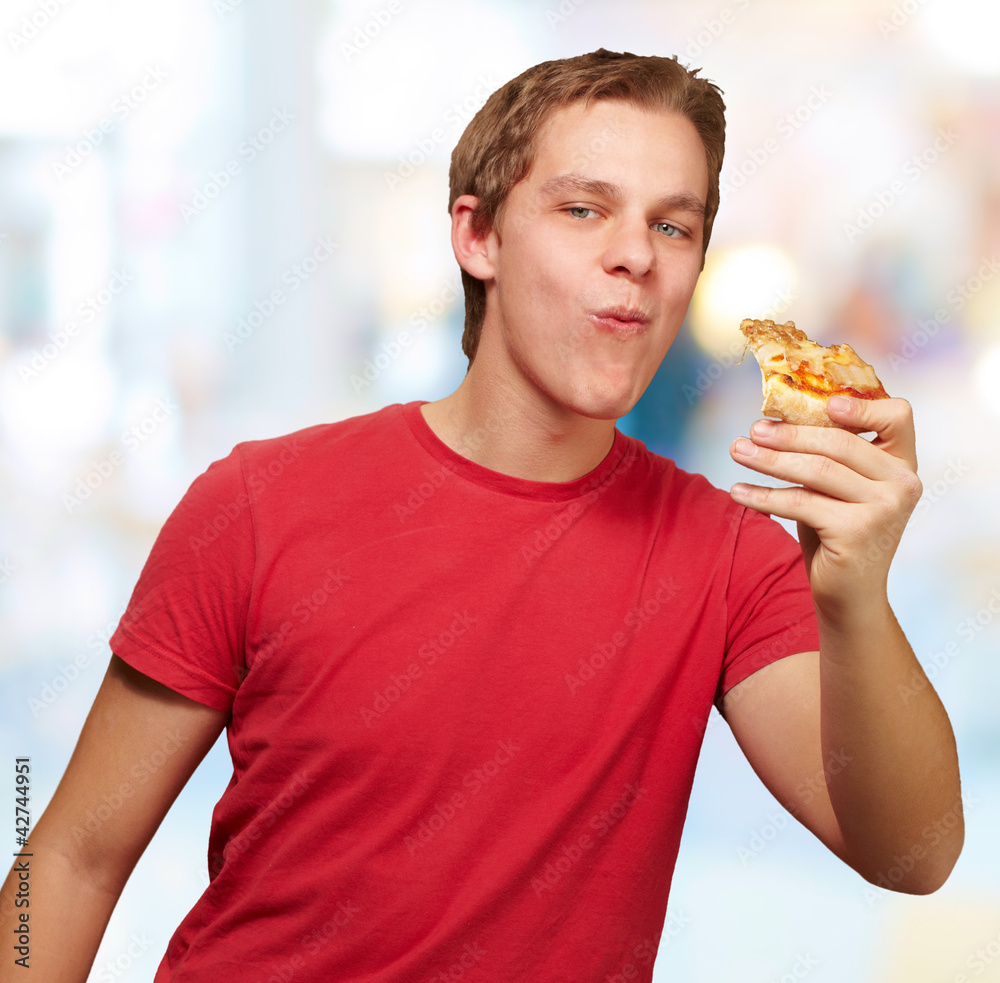 portrait of young man eating pizza portion indoor Stock Photo | Adobe Stock