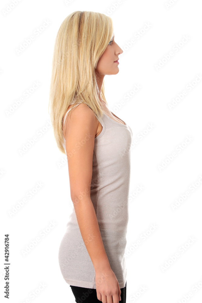 Young woman is standing sideways. Stock Photo | Adobe Stock