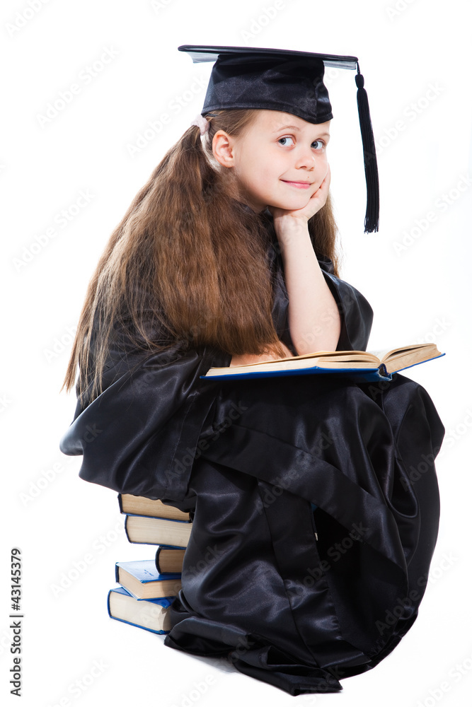 girl in black academic cap and gown reading big blue book Stock Photo ...