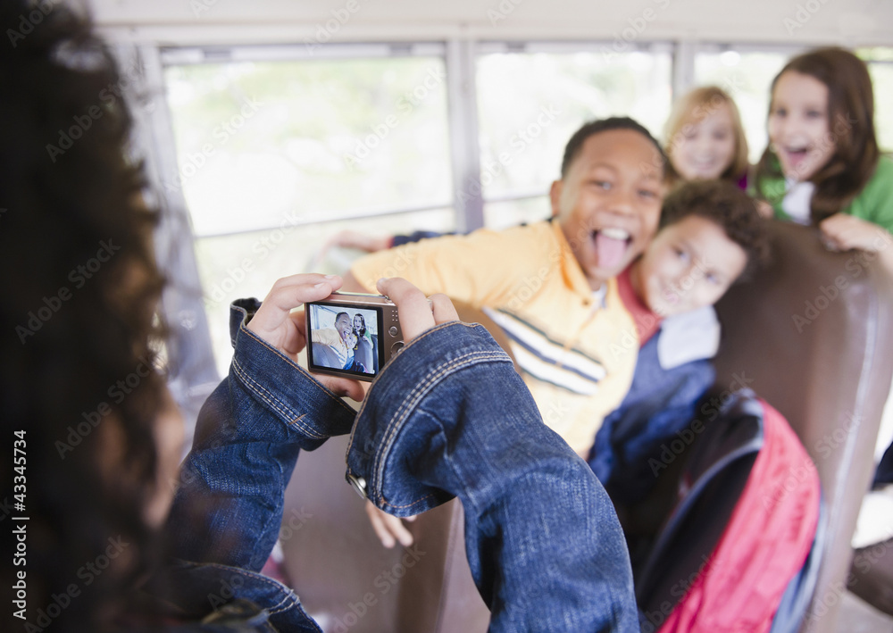 Girl taking photographs on school bus Stock Photo | Adobe Stock