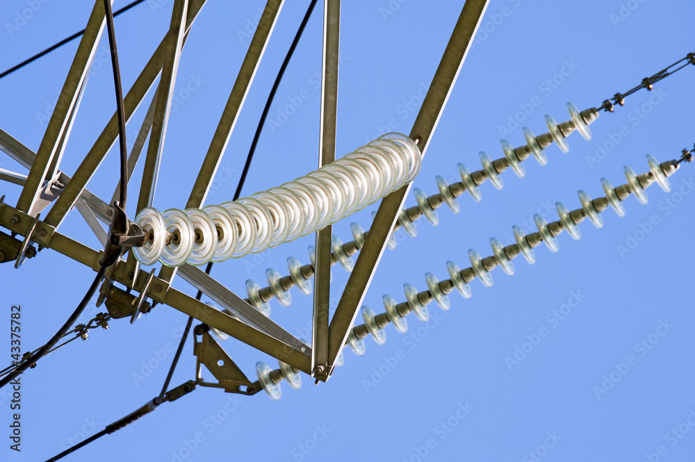 insulators of high-voltage power lines on blue sky background Stock ...