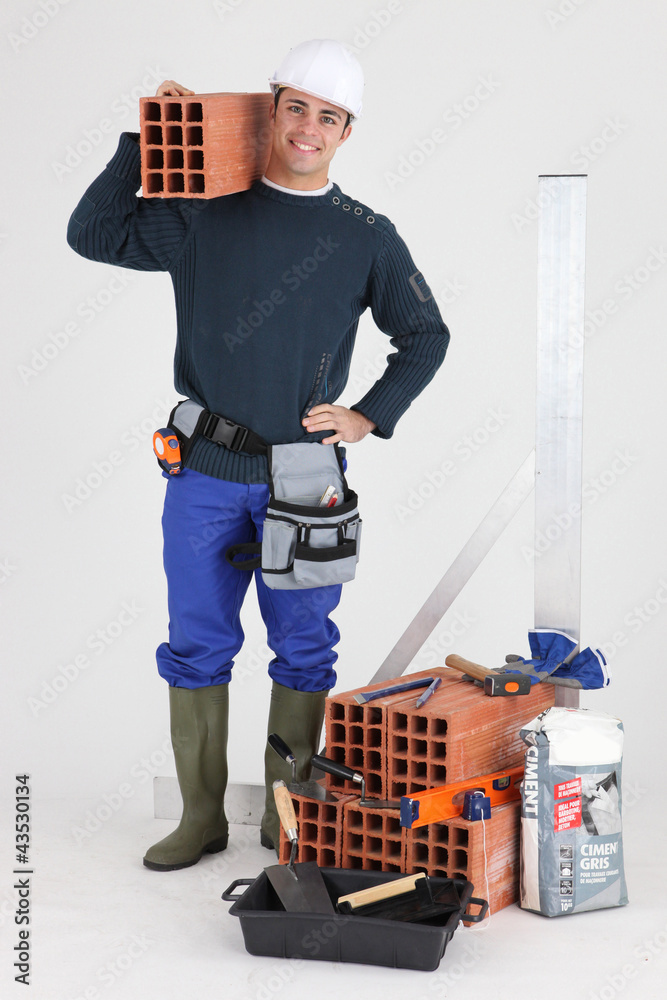 Poster A bricklayer posing with his tools and building materials ...