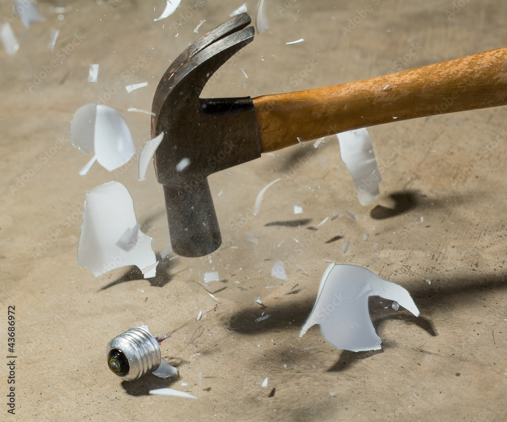 Hammer hitting incandescent light bulb Stock Photo | Adobe Stock