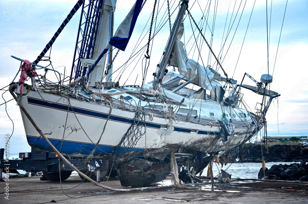Storm-damaged yacht on Easter Island in the Pacific Ocean. Hole in the ...