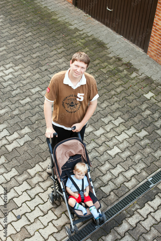 Young man pushing stroller with a baby toddler Stock Photo | Adobe Stock
