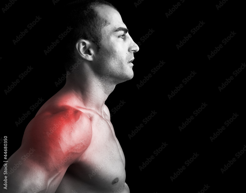 Muscular man suffering with shoulder pain on black background Stock ...