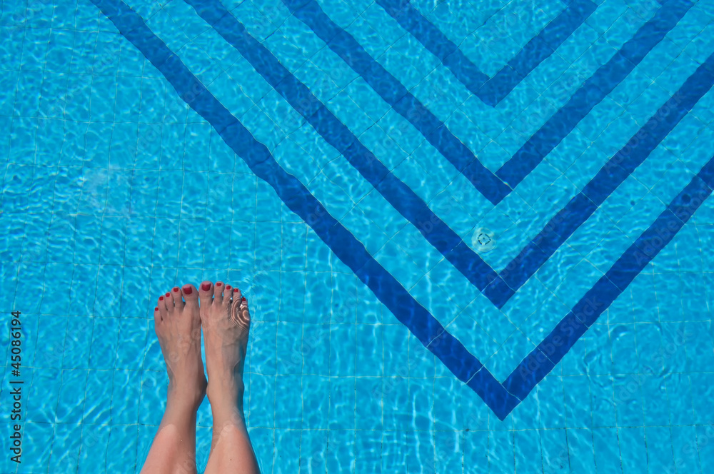 Woman's feet in a swimming pool Stock Photo | Adobe Stock