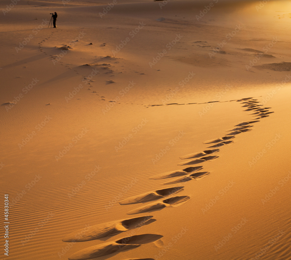 Man walking on sand Stock Photo | Adobe Stock