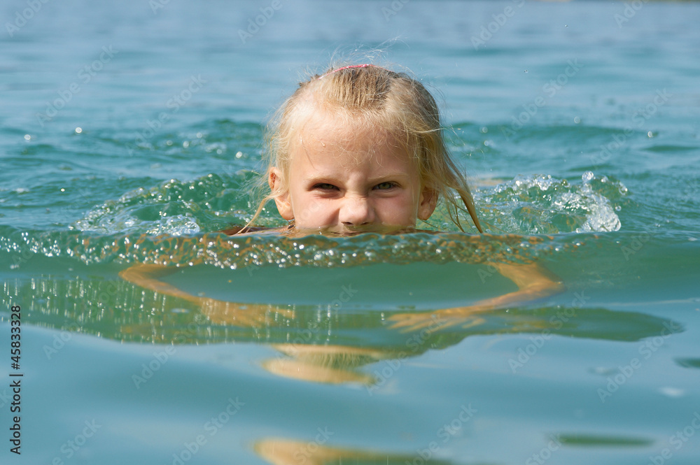 Little girl swimming in lake Stock Photo | Adobe Stock
