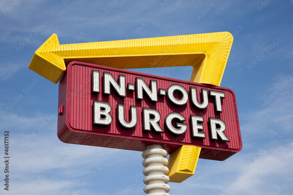 A classic IN-N-OUT BURGER sign in front of sky with yellow arrow Stock ...