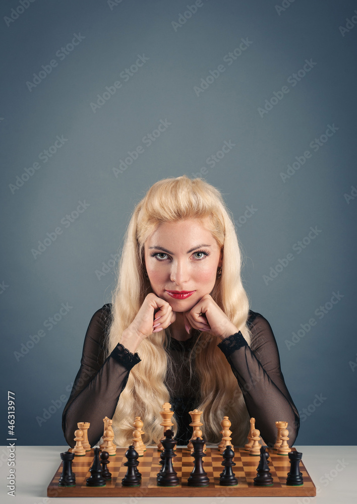 Beautiful blonde woman playing chess on dark background. Stock Photo ...
