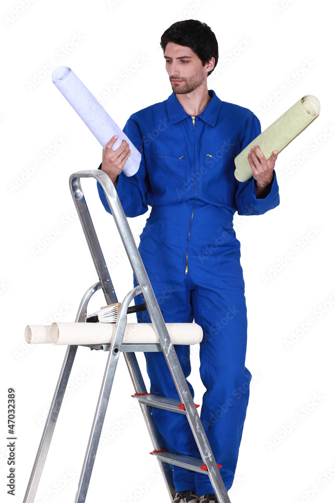 Man stood on step-ladder choosing which color wallpaper to use Stock ...