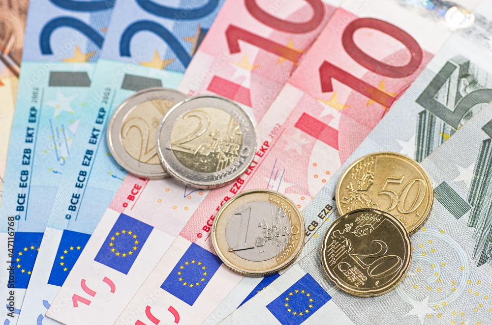 aufgefächerte Geldscheine mit Münzen Stock-Foto | Adobe Stock